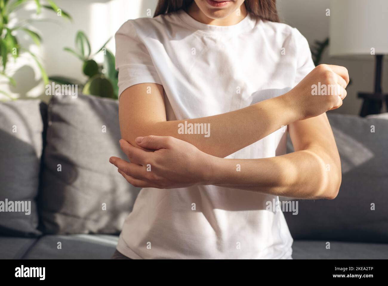 Close up of young woman with arm pain. Unhealthy caucasian girl ...
