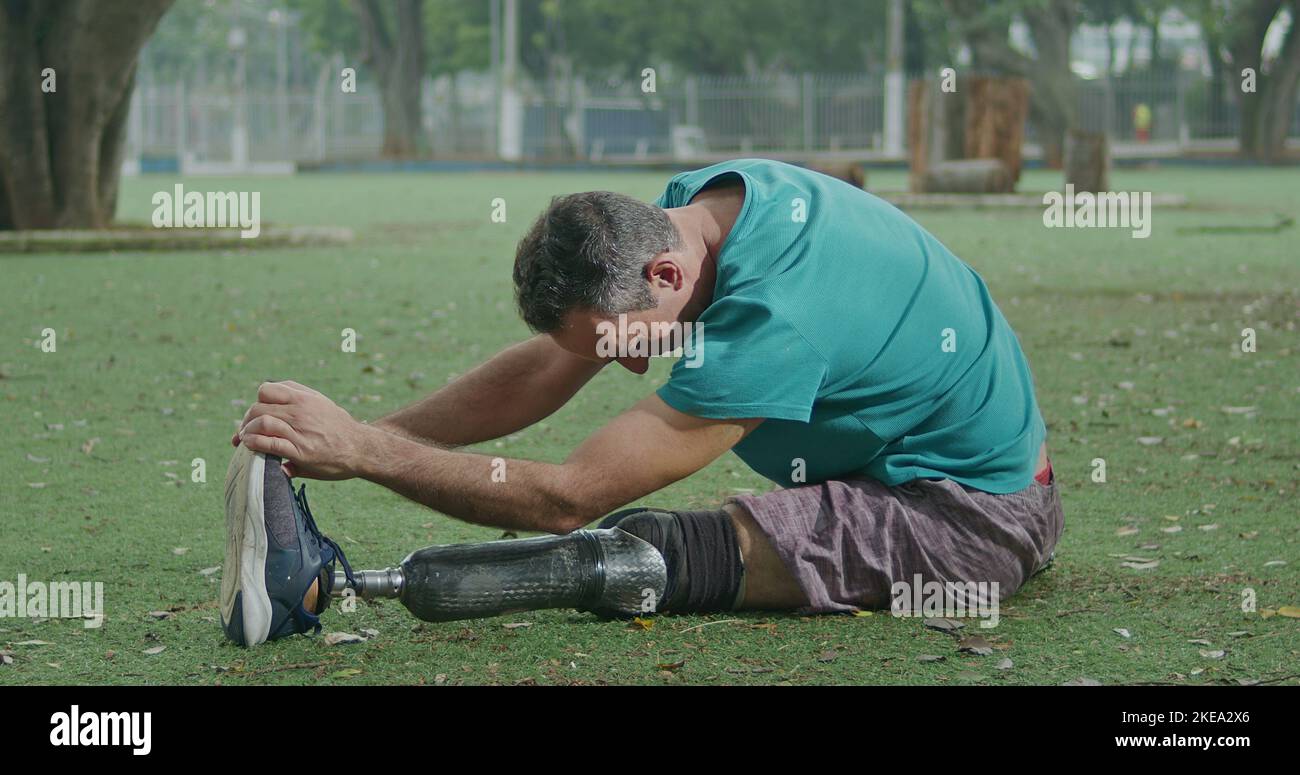 One motivated older middle aged disabled athlete stretching prosthetic ...