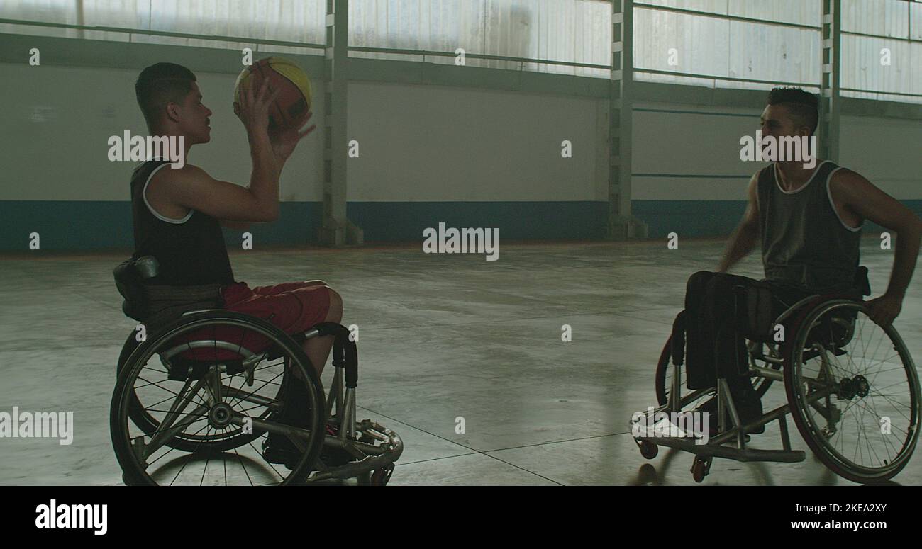 Two Brazilian hispanic paraplegic disabled athletes playing basketball ...