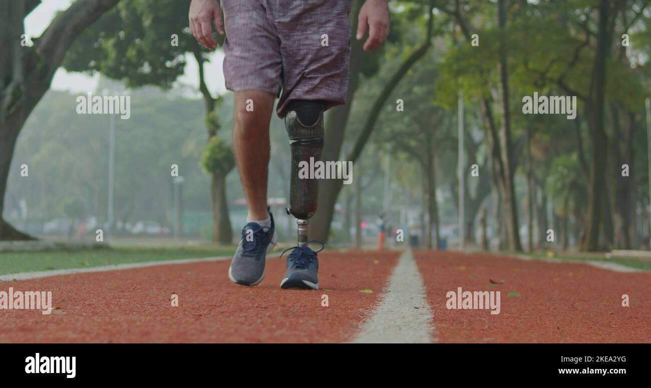 Front view of a middle aged disabled athlete man with prosthetic leg ...