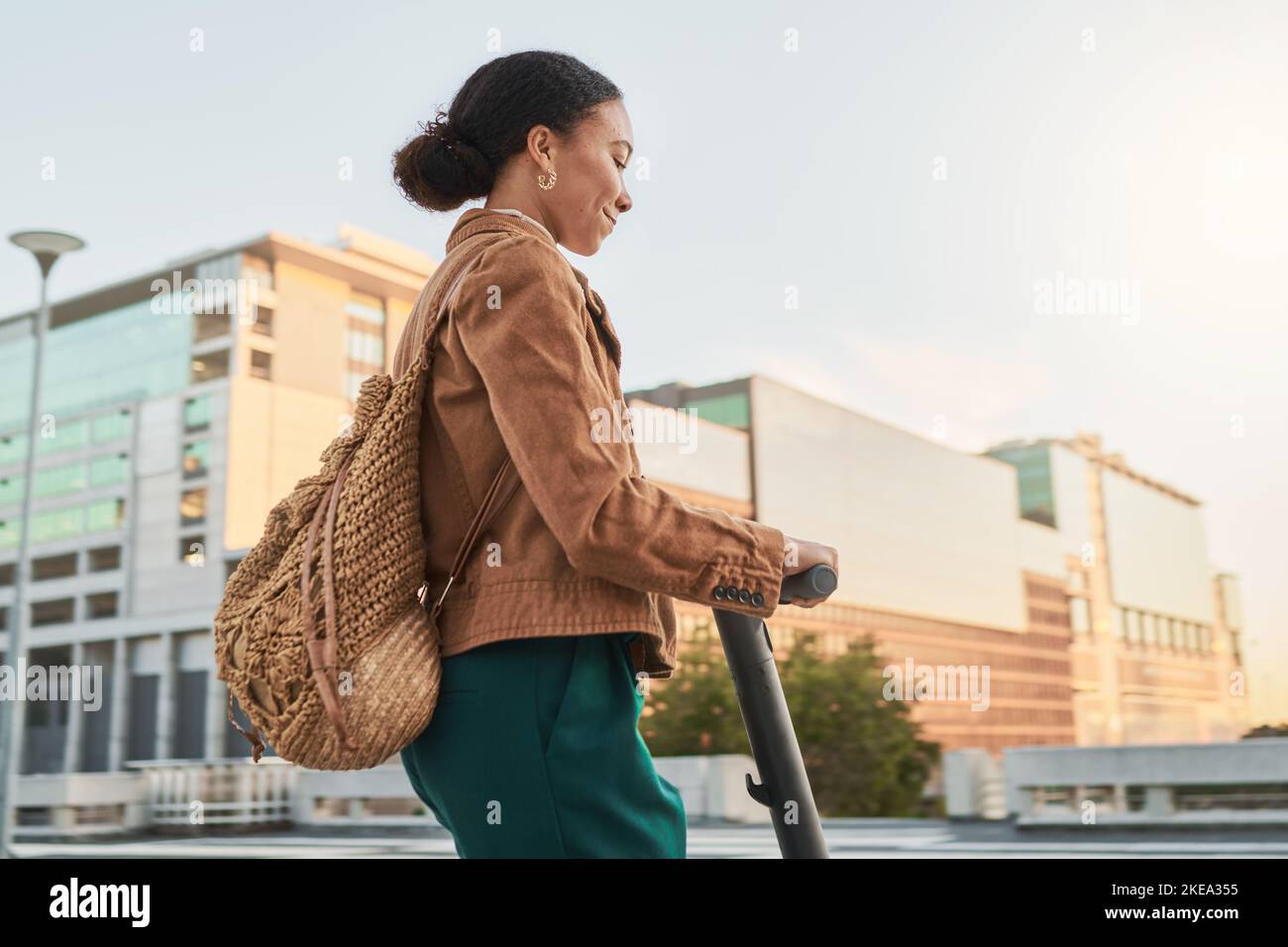 Black woman, electric scooter and city buildings while on road to ...
