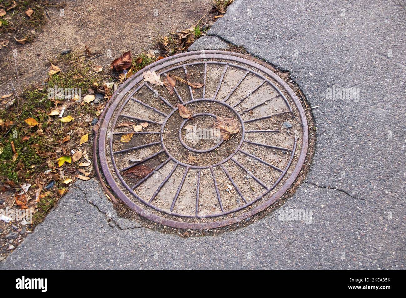 Sewer manhole with lid on the sidewalk close up Stock Photo - Alamy