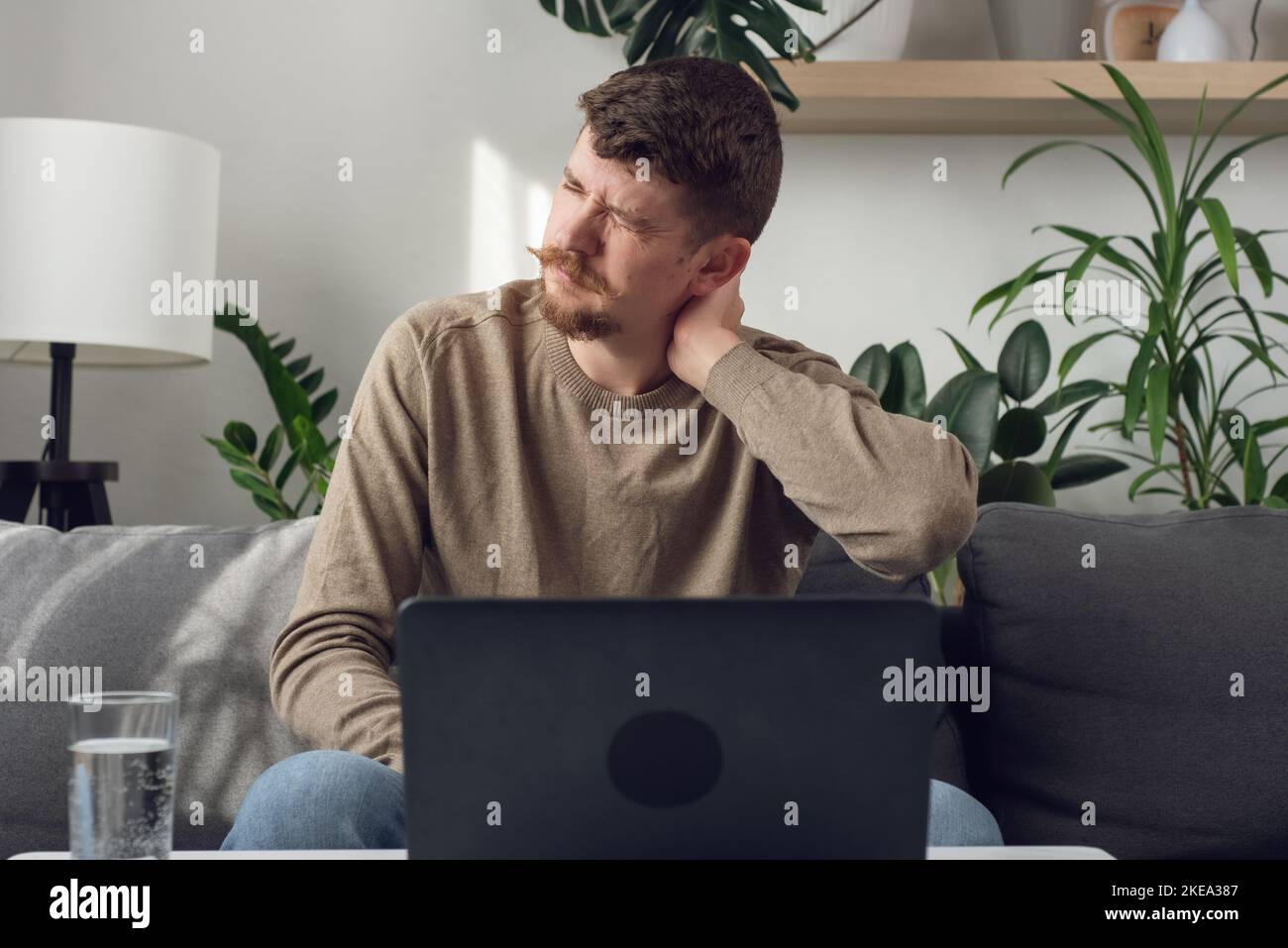 Tired unwell guy overwhelmed with computer work sedentary lifestyle ...