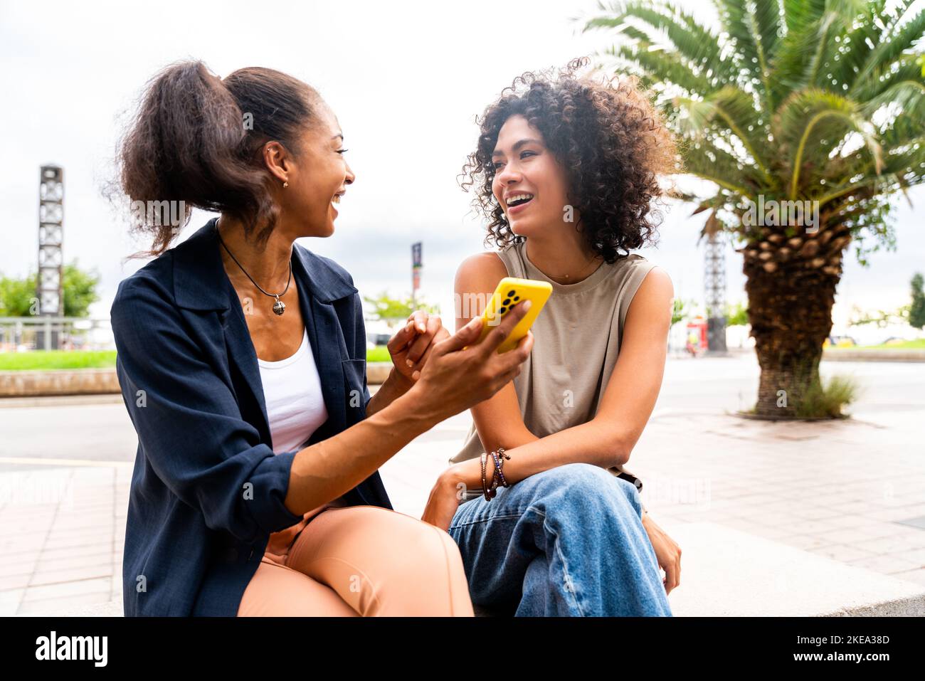 Happy beautiful hispanic south american women meeting outdoors and ...