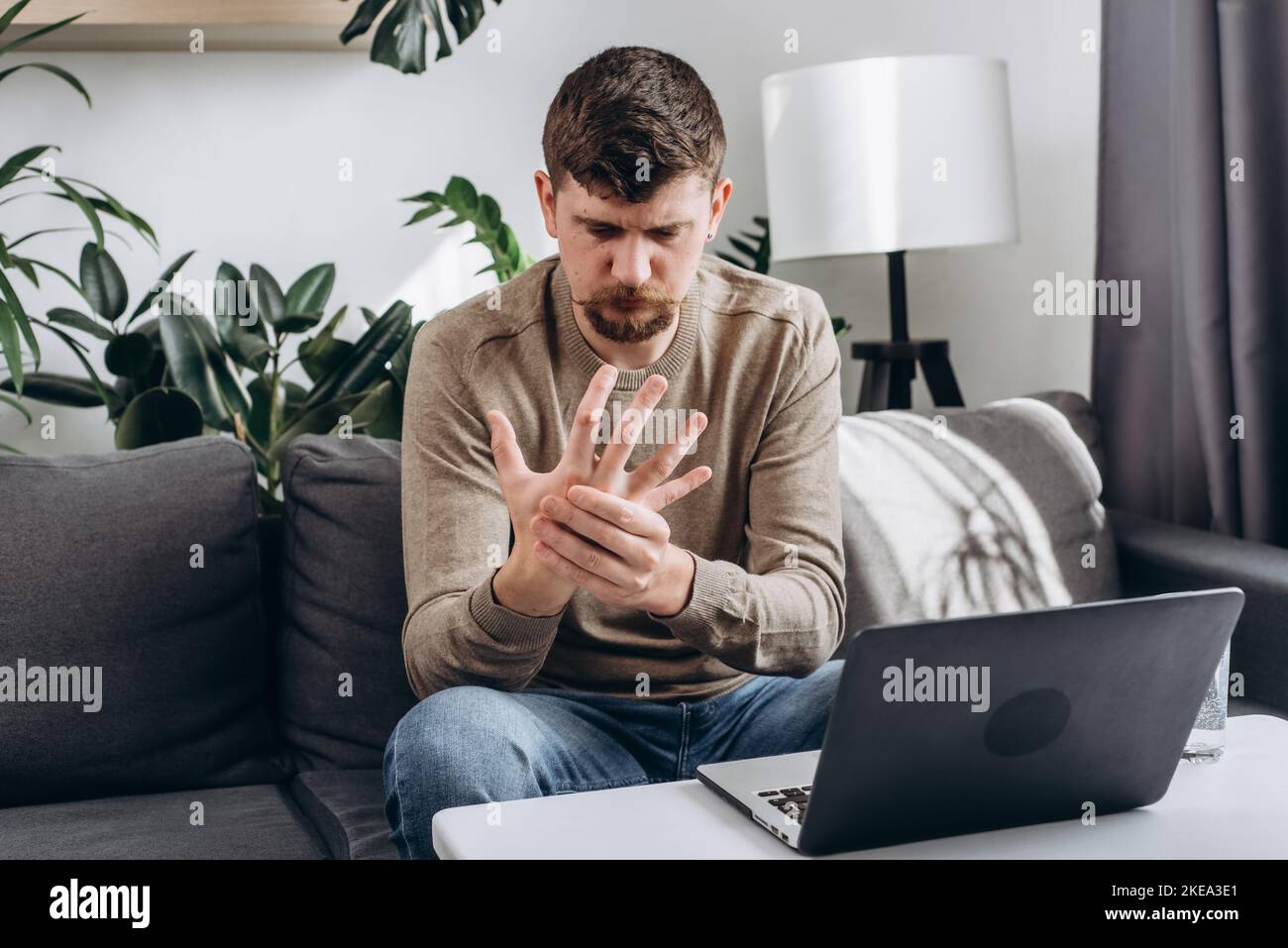 Close-up of young bearded man at computer working place and ...