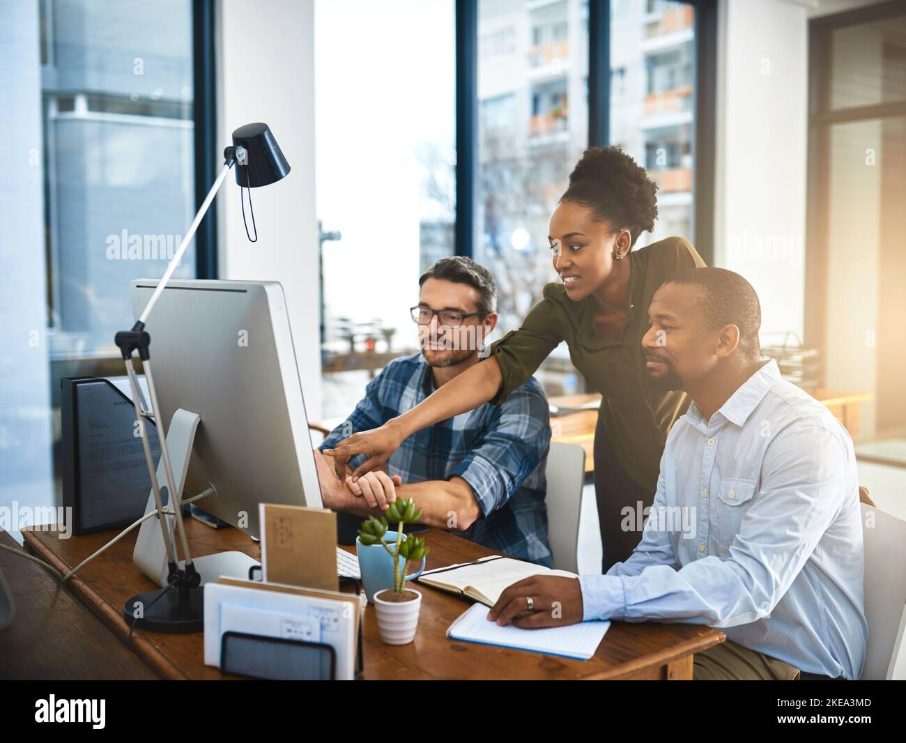 Thats interesting...three businesspeople working around a computer in ...