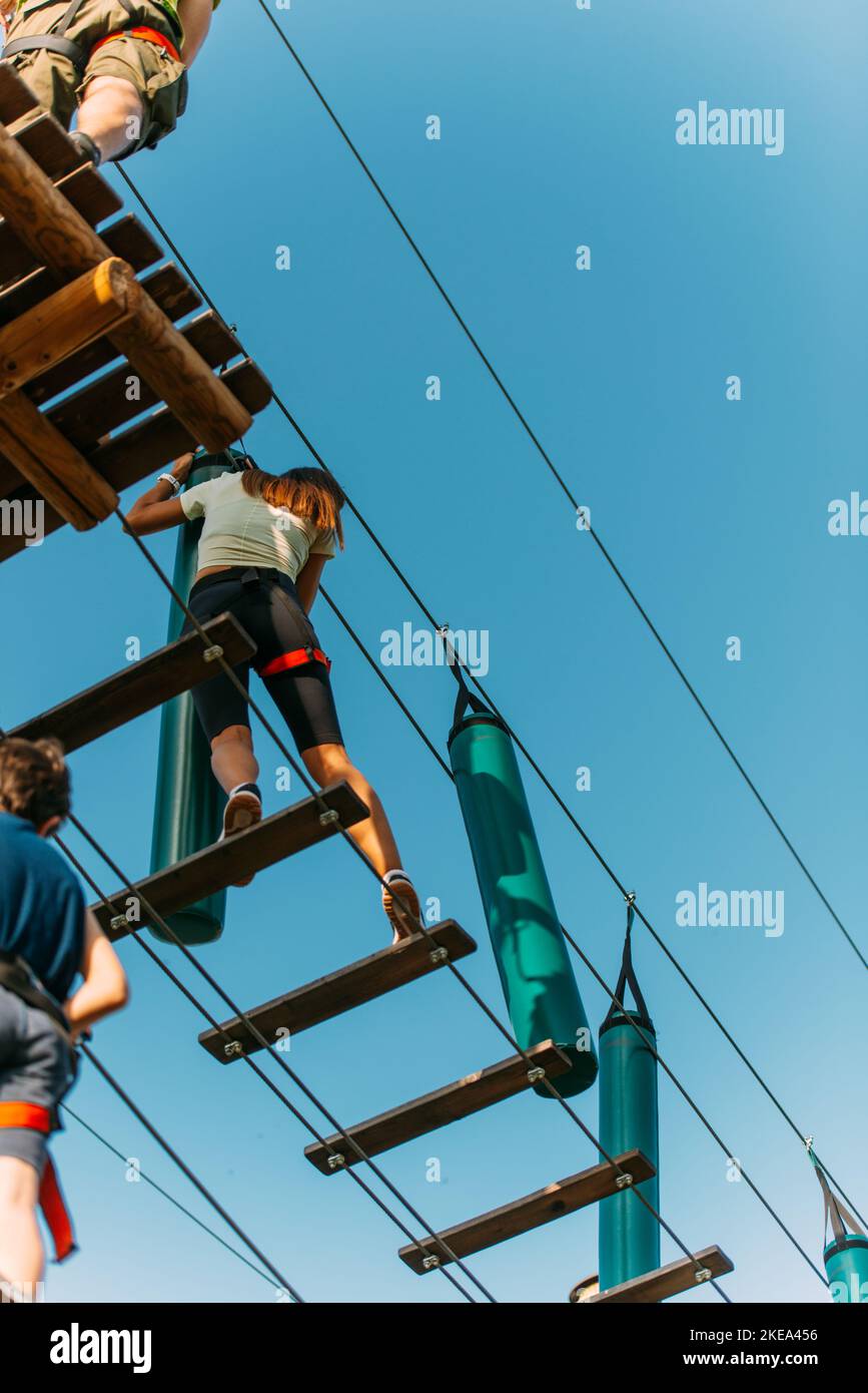 Young professional climber clearing the ladder obstacle with ease in ...