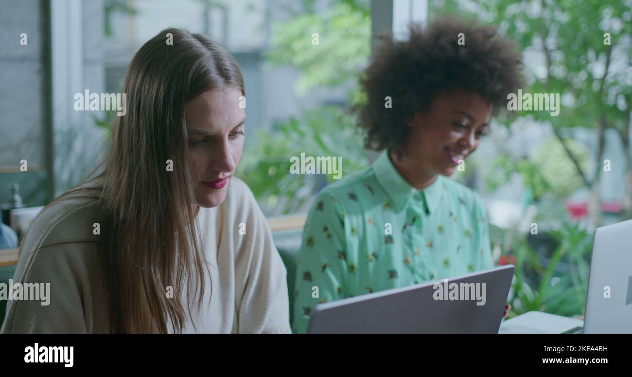 Two young women in front of laptop computers working. Female work ...