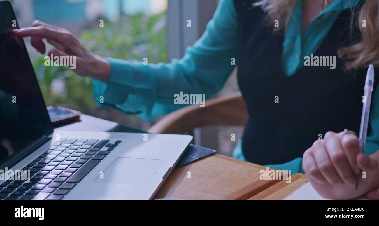 Mature woman boss explaining work to female employee at cafe business ...
