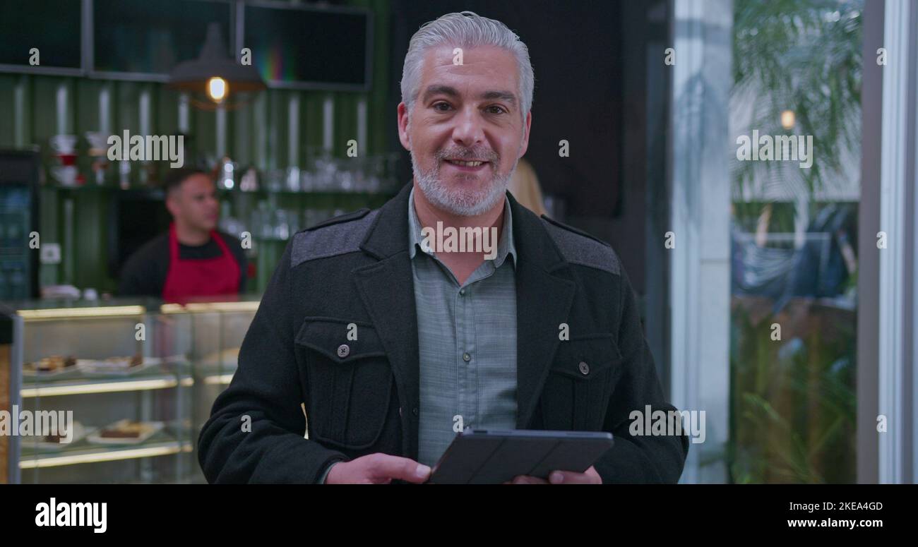 One confident middle aged owner of small business place looking at ...