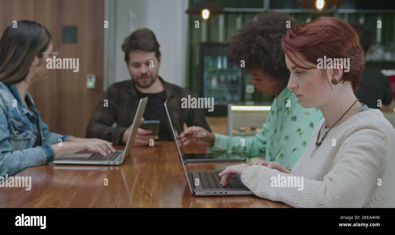 Group of young millennials working in front of laptop computers seated ...