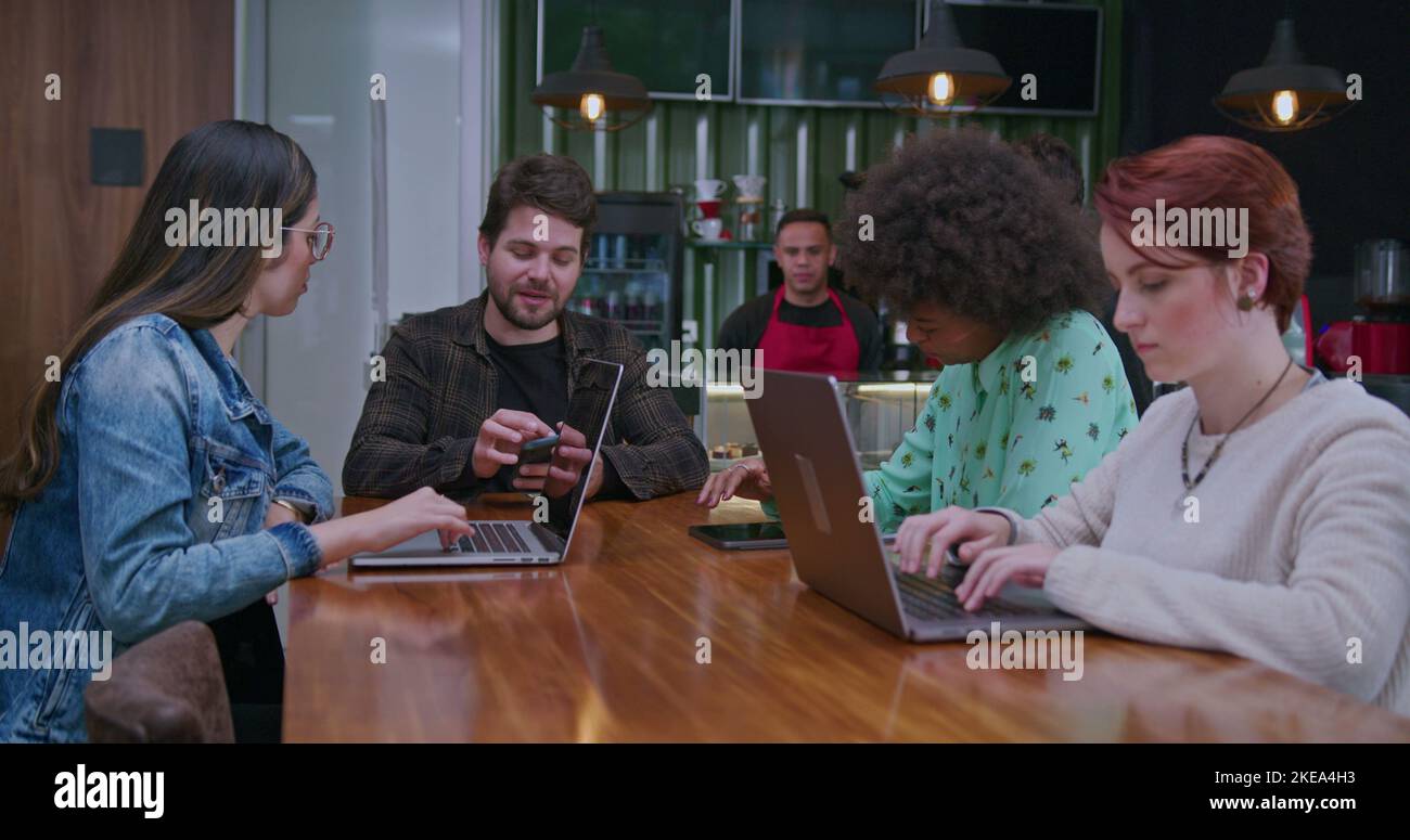 People using devices at coffee shop interior. Group of work colleagues ...