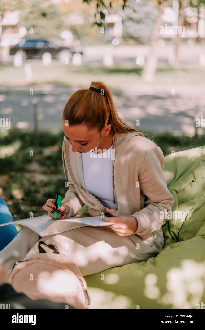 High school girl is underlining important parts in the book with a ...