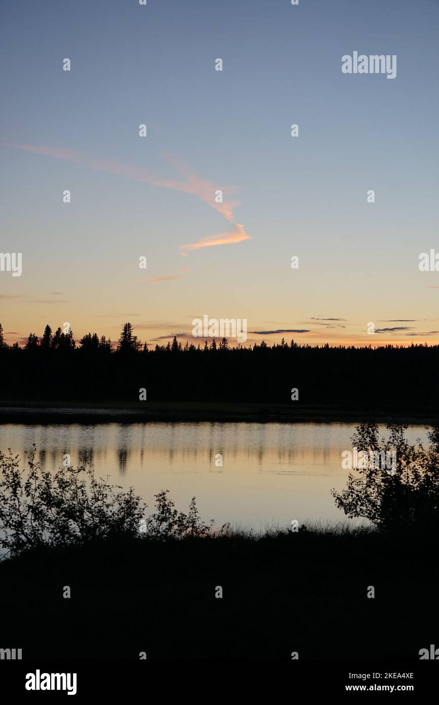 A beautiful view of a calm lake against a scenic sunset Stock Photo - Alamy