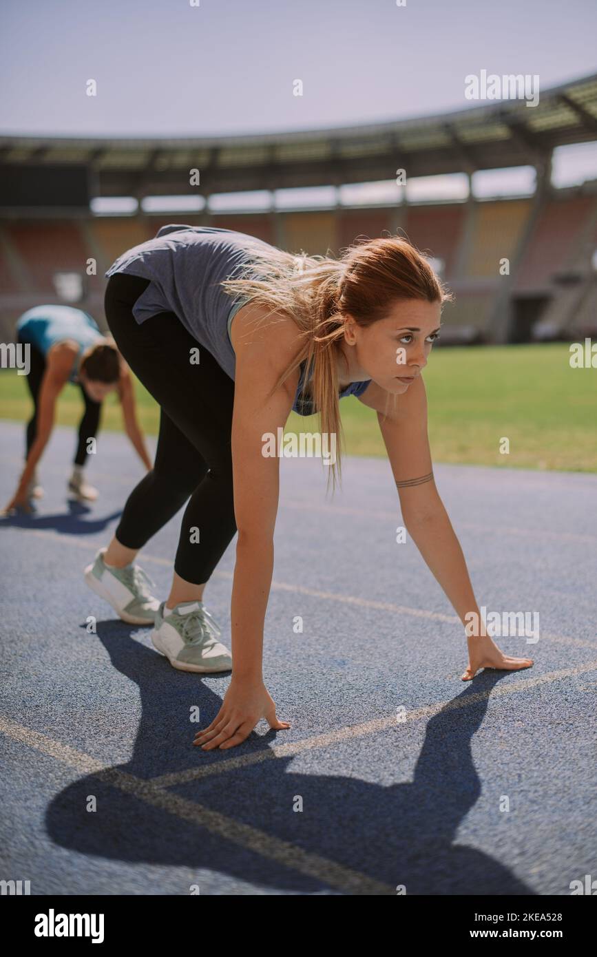 A gorgeous blonde girl is looking at the finish line before running ...