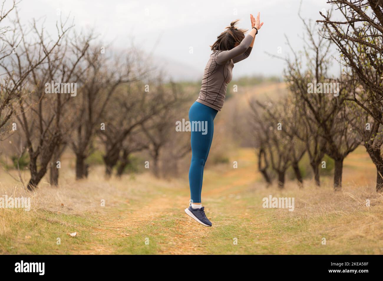 Sport girl is jumping and working out in nature Stock Photo - Alamy