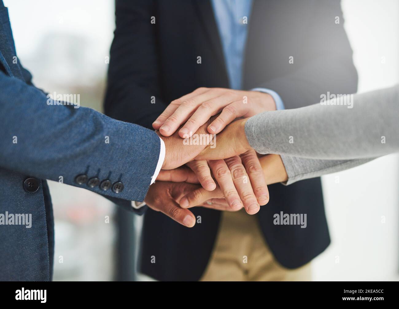 Decide, commit, succeed. a team of colleagues joining their hands ...