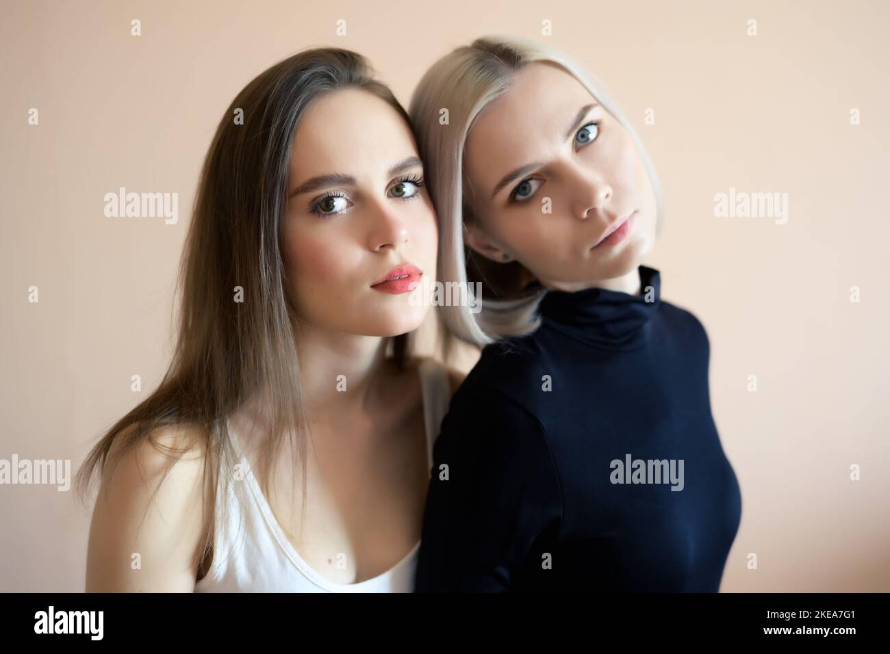 Two young women on a light background Stock Photo - Alamy