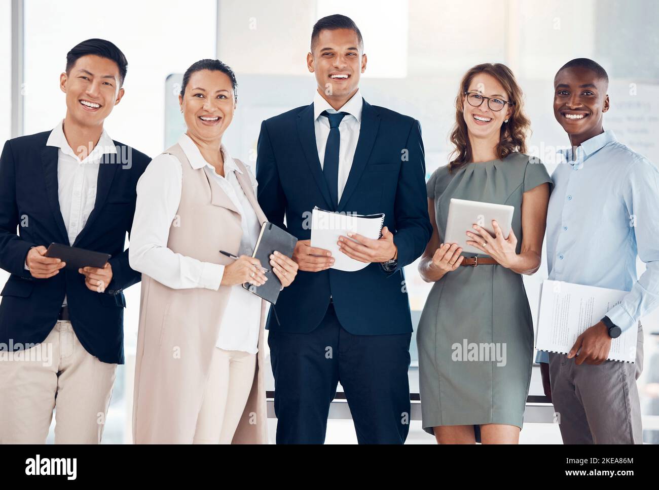 Portrait of diversity business people with notebook, tablet and stand ...