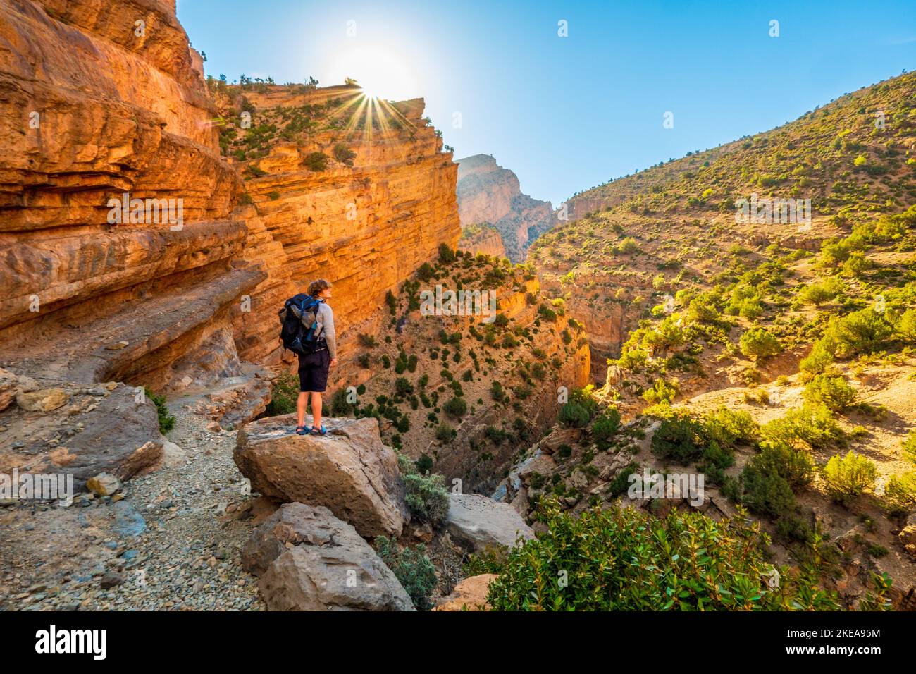 A trekker on a man made stairway up the canyon side of the M'Goun Gorge ...