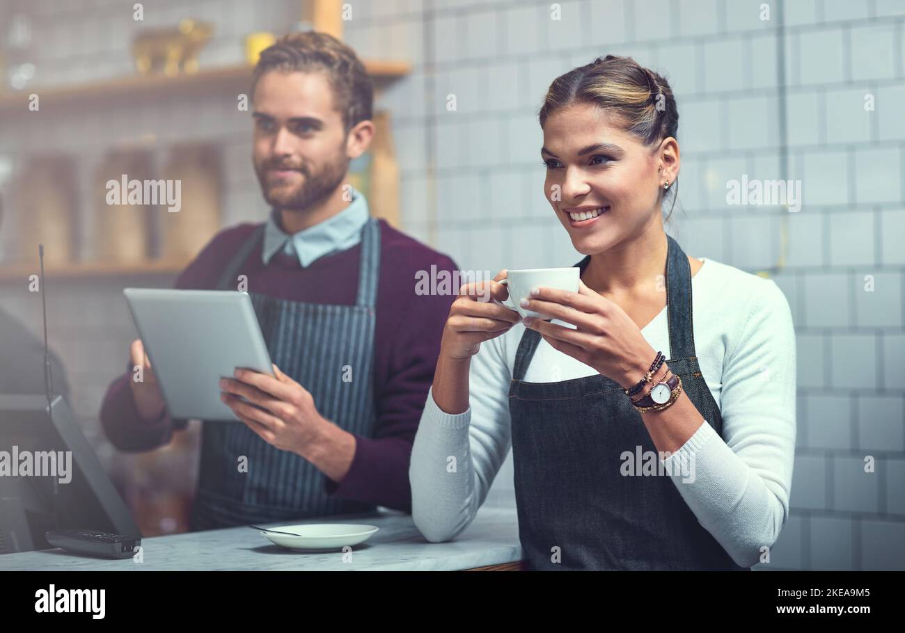 The perks of owning a cafe, great coffee on tap. a young woman having ...