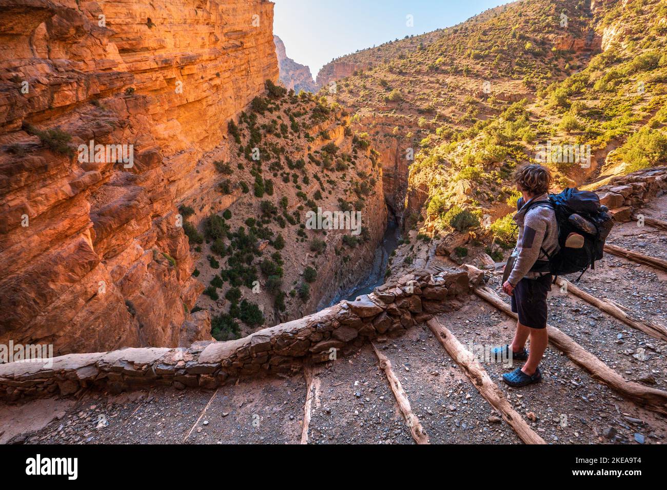 A trekker on a man made stairway up the canyon side of the M'Goun Gorge ...