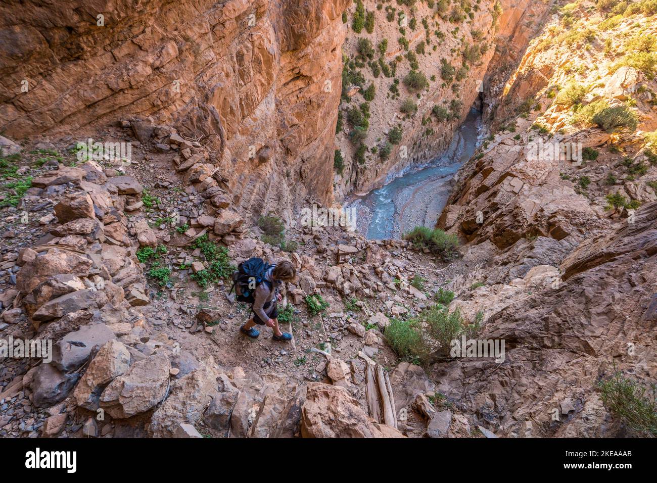 A trekker on a man made stairway up the canyon side of the M'Goun Gorge ...