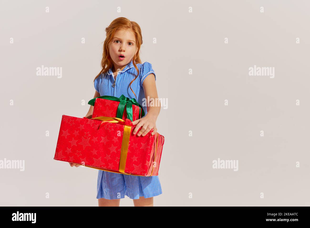 Portrait of little redheaded girl, child with present box isolated over ...