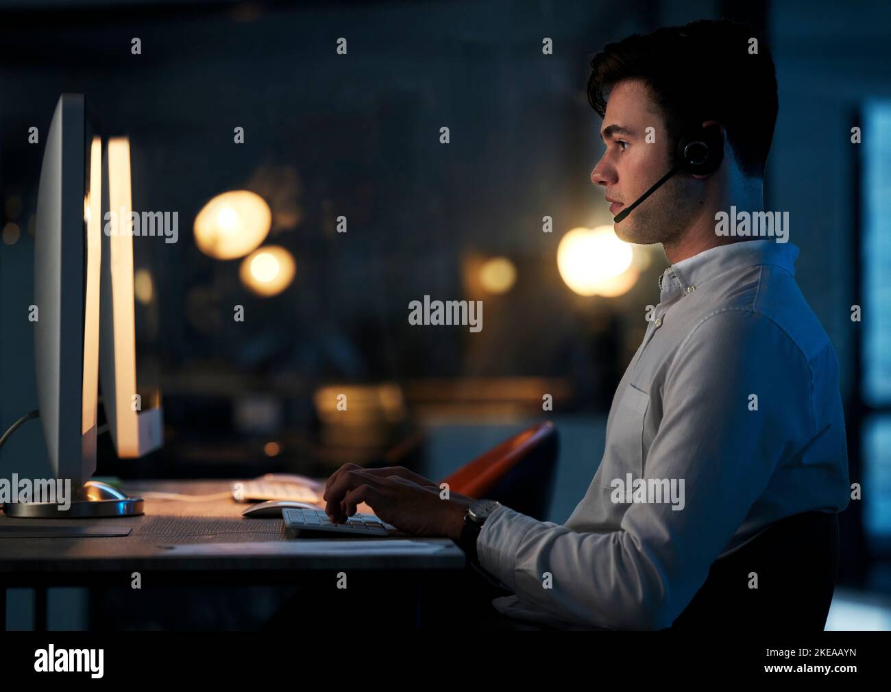 Call center, night office and employee typing, working late shift or overtime for commission ...