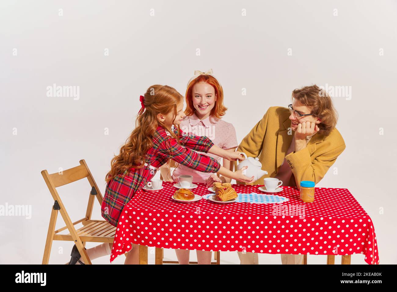 Morning talk. Beautiful young couple with cute daughter sitting at the ...