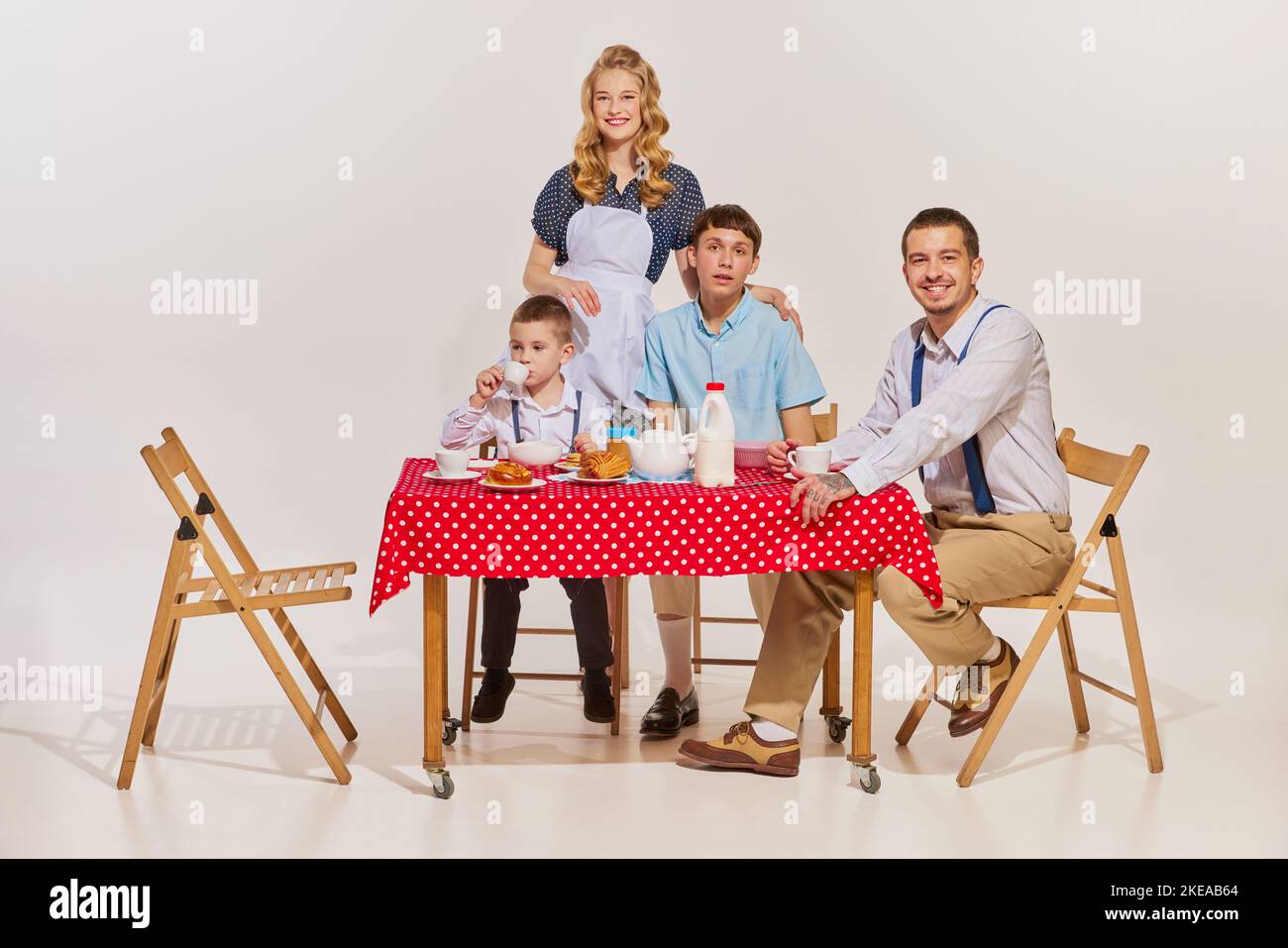 Portrait of lovely young family, woman, man and two boys sitting at the ...
