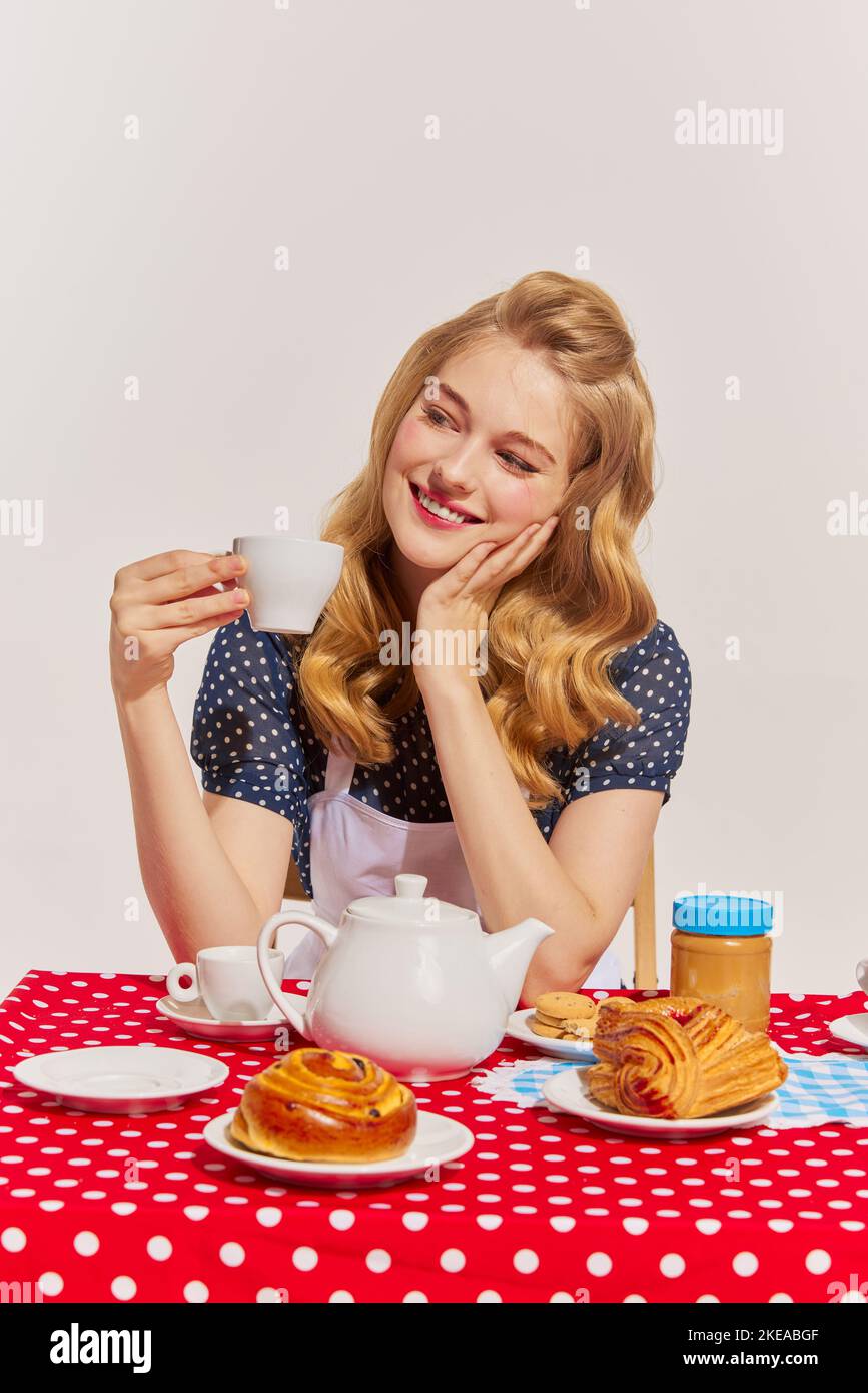 Portrait of lovely young woman having breakfast isolated over grey ...