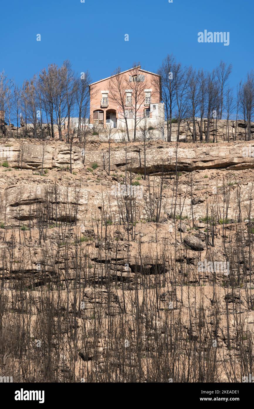 Isolated house on mountain top burned by forest fire. El Pont de ...