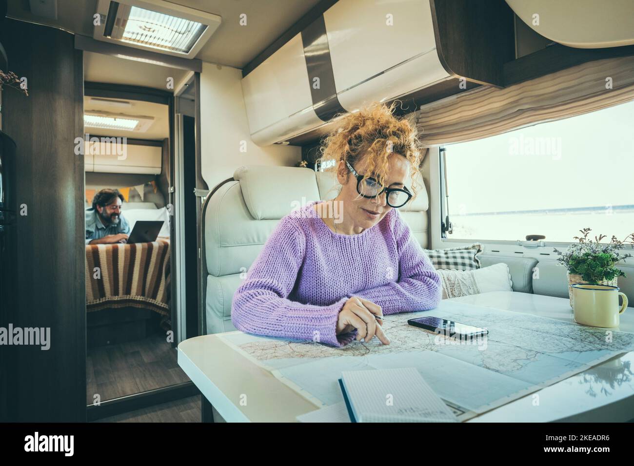 People man and woman in van life day inside camper van. Woman using ...