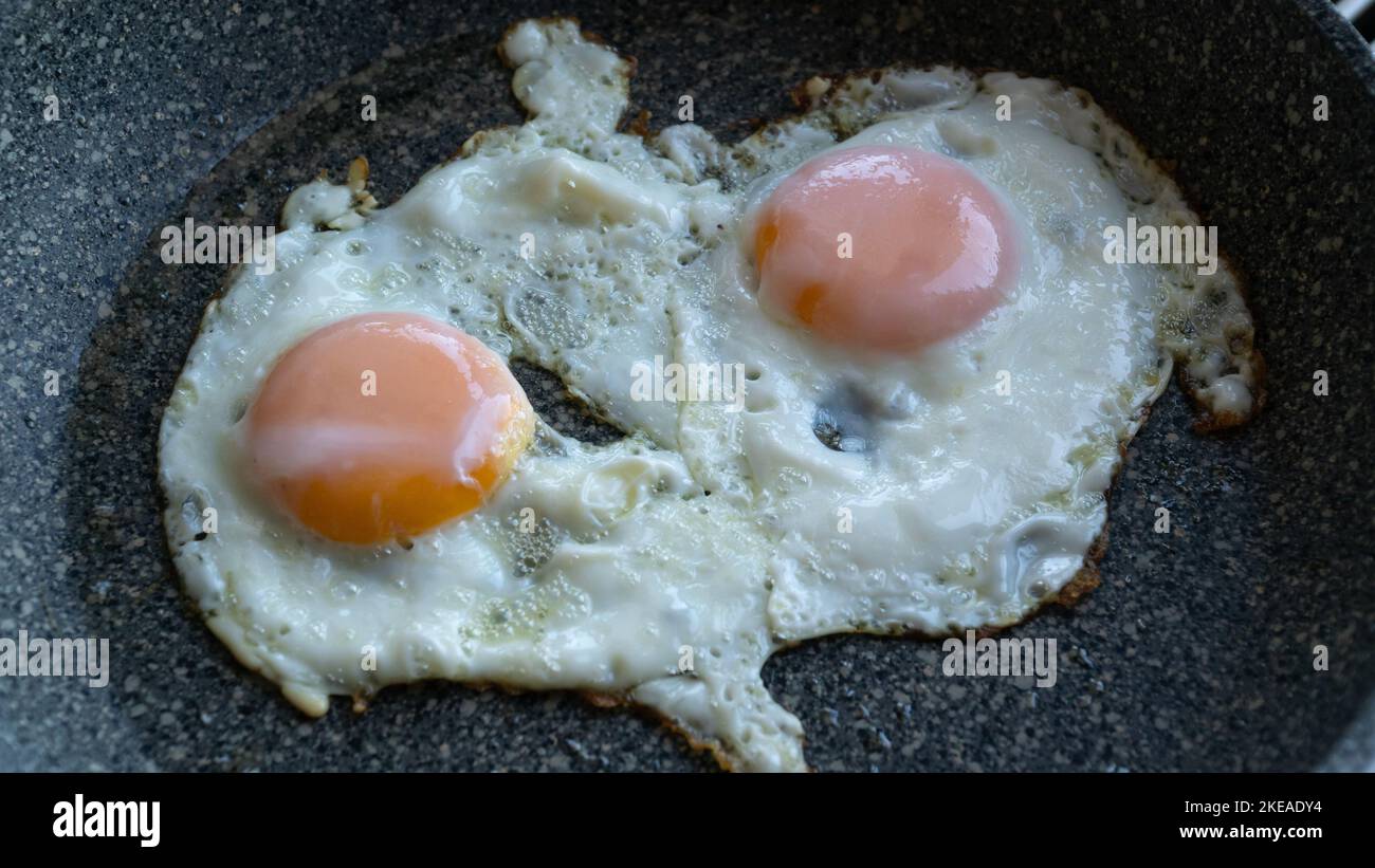 Sunny side up egg in the pan. Cooking eggs on the stove for breakfast ...