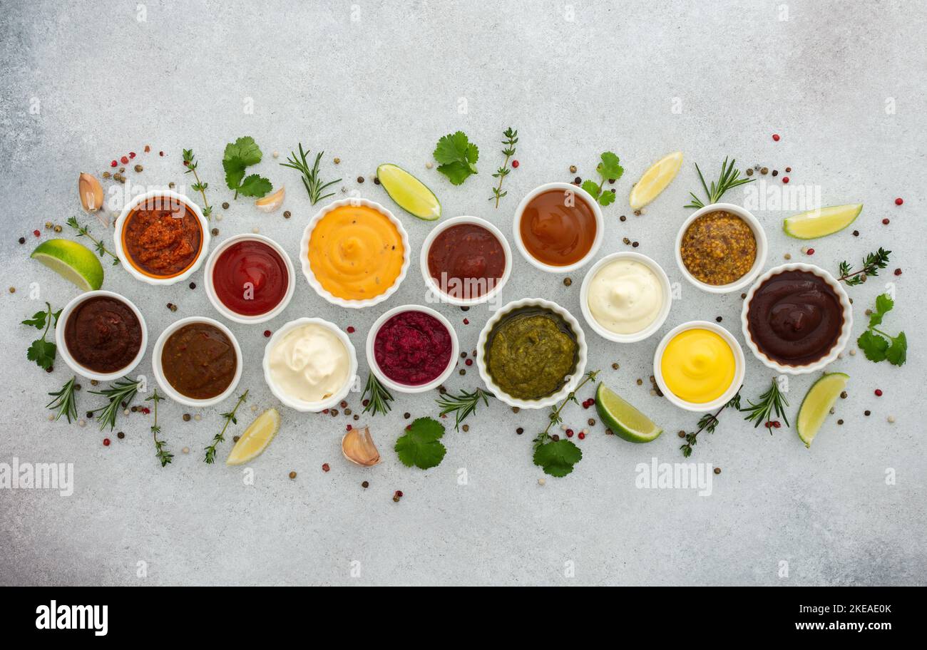 Different types of sauces in bowls with seasonings, rosemary and pepper ...