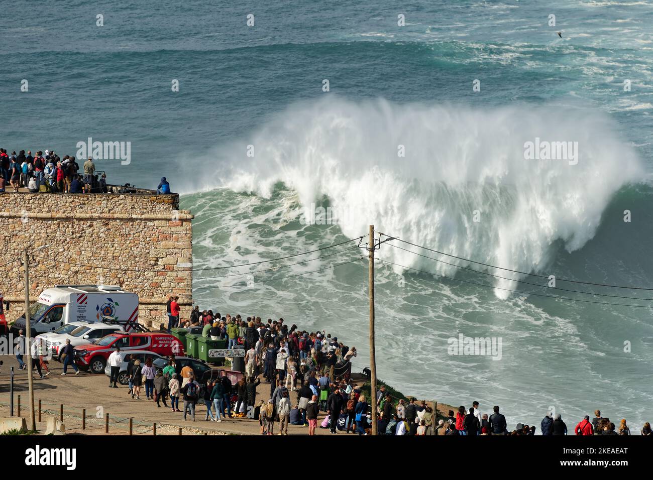 People watching the big giant waves crashing near the Fort of Nazare ...