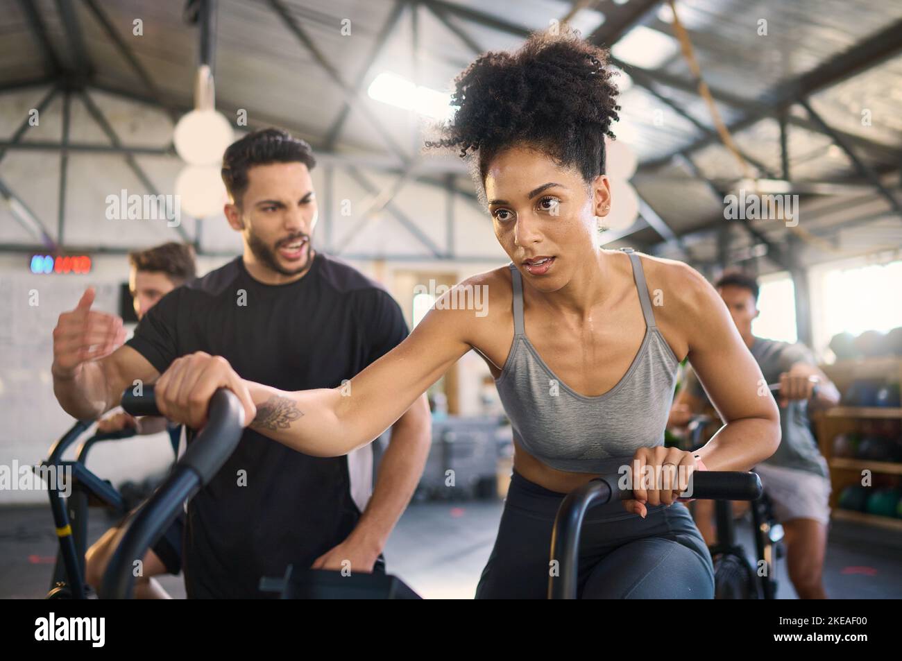 Exercise bike, motivation and personal trainer with a black woman in ...