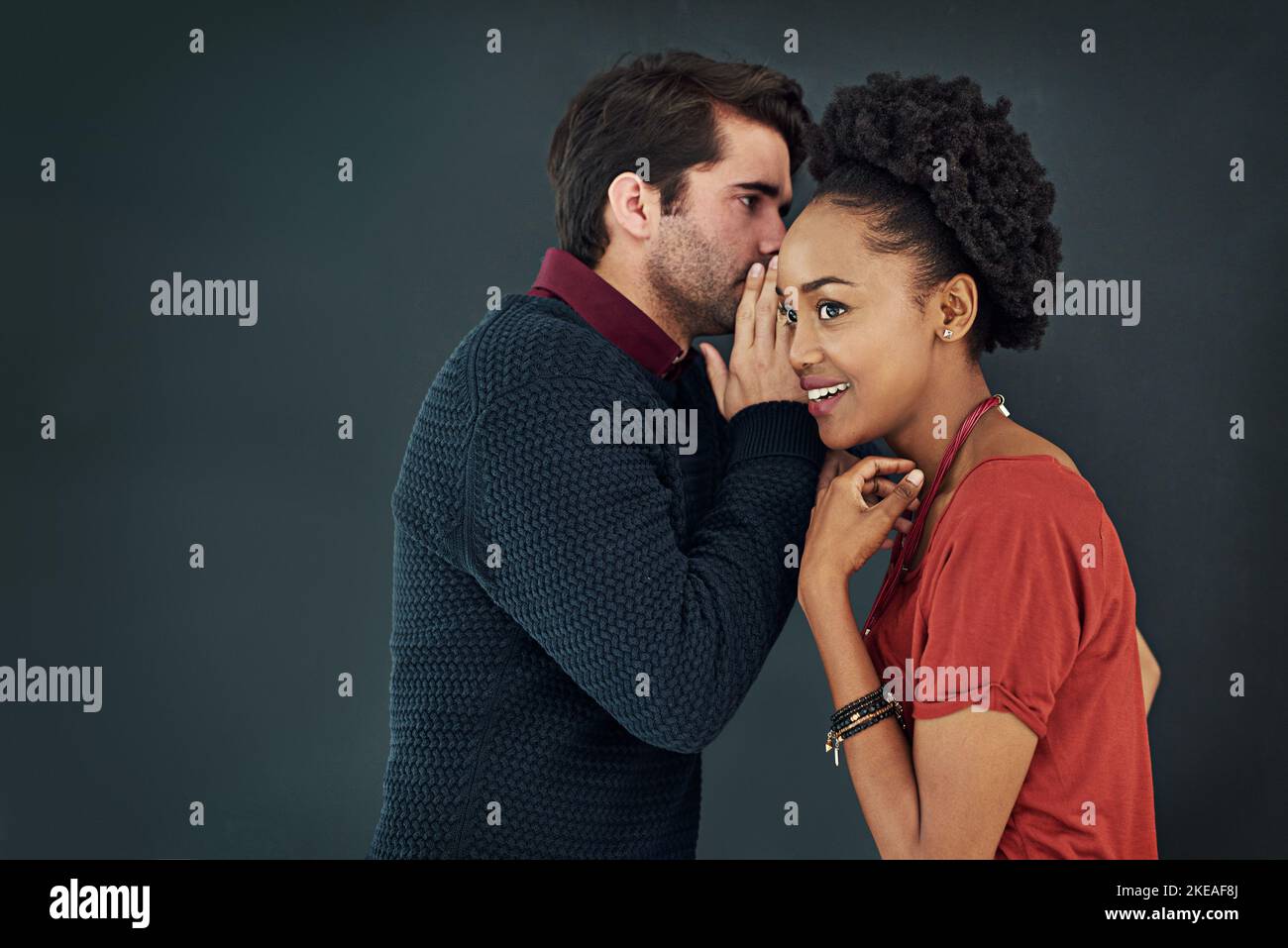 Have you heard. two people gossiping against a dark background Stock ...