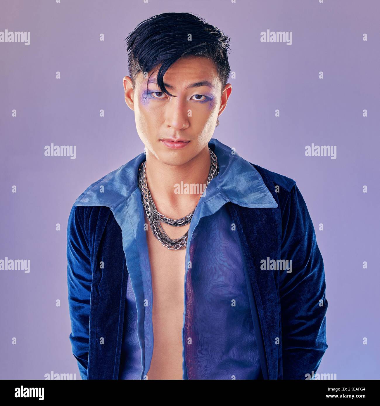 Art, purple and creative portrait of man with makeup, serious face and ...