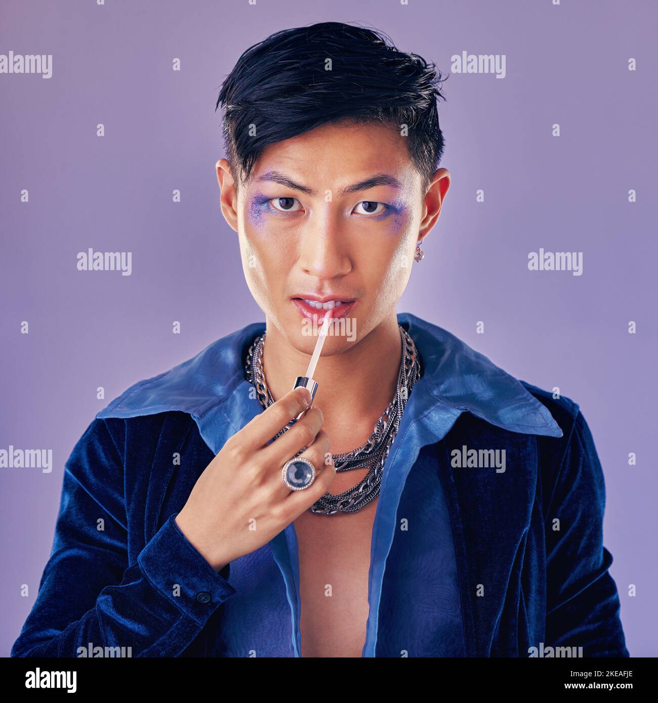 Fashion, beauty and makeup with a man model in studio on a purple ...