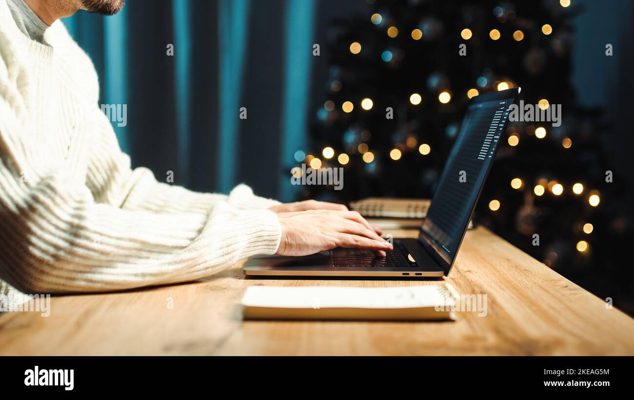 Working on laptop while sitting at home with Christmas decorations ...