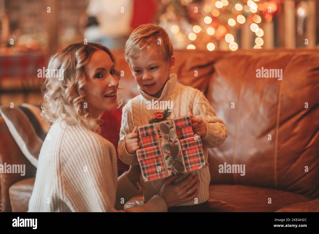 Portrait of happy family mom with small son in knitted beige sweaters ...