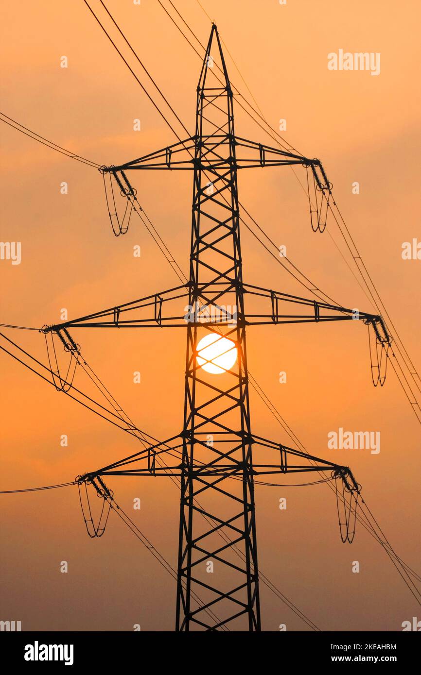 Setting sun behind the silhouettes of current poles, Switzerland Stock ...