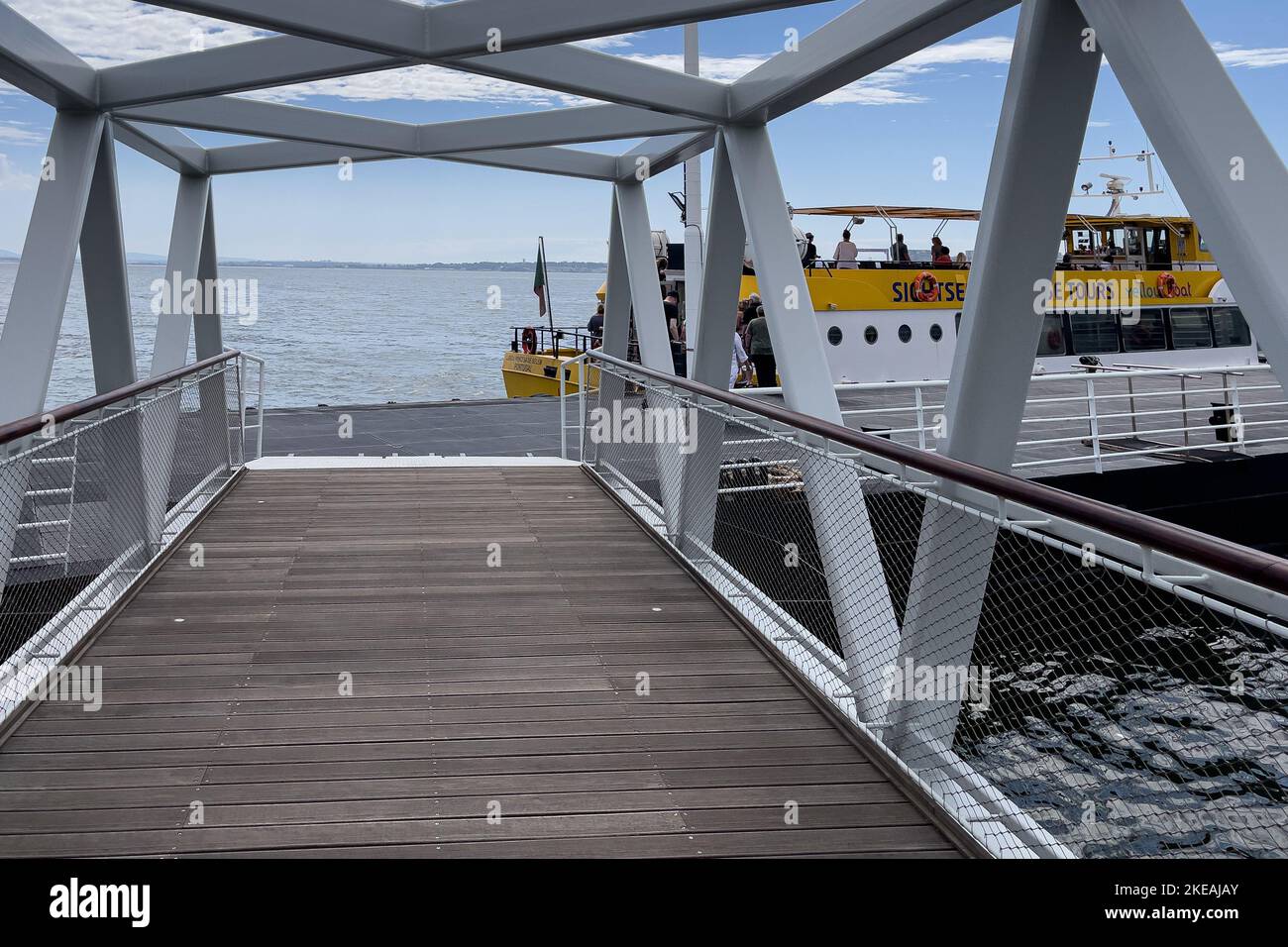 Passengers crossing a small bridge towards the ferryboat for a tour ...