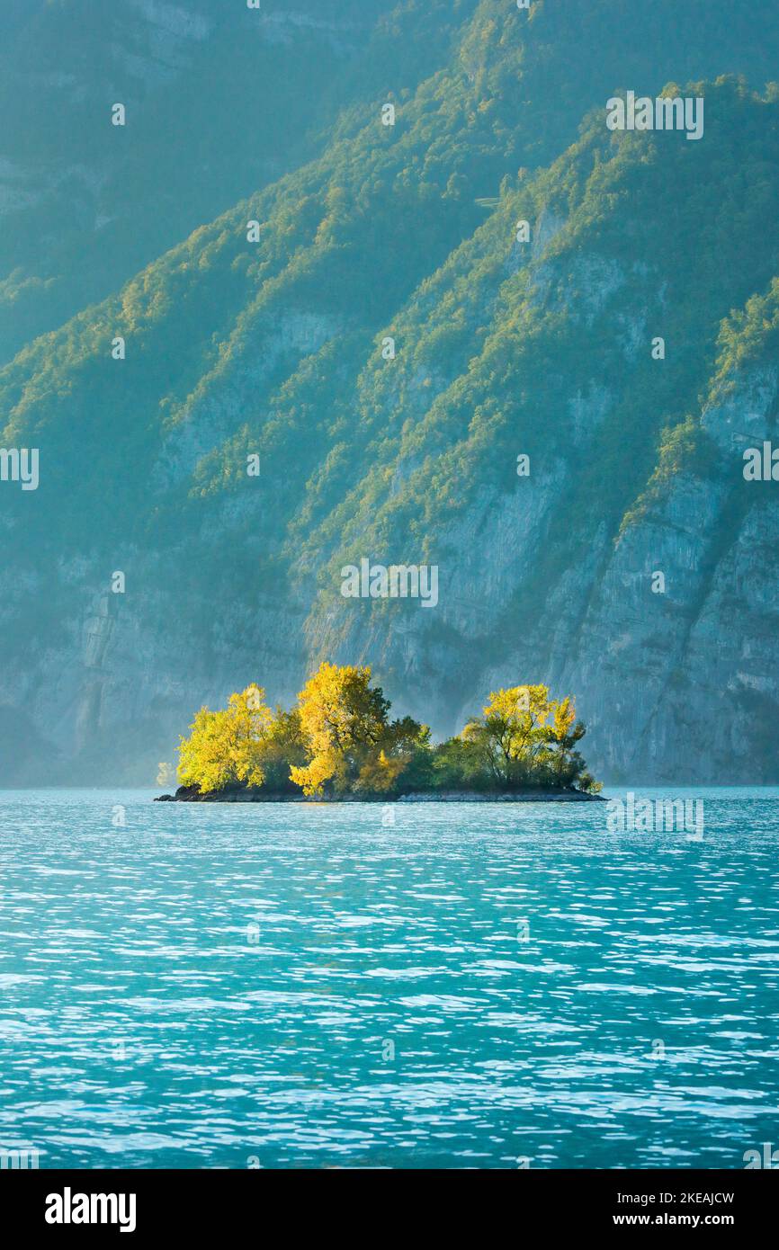 Small island in the turquoise water of Lake Walen, Switzerland, St ...