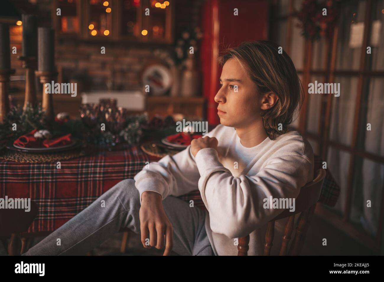 Young teen boy with long hair thoughtful look sad eyes negative mood ...