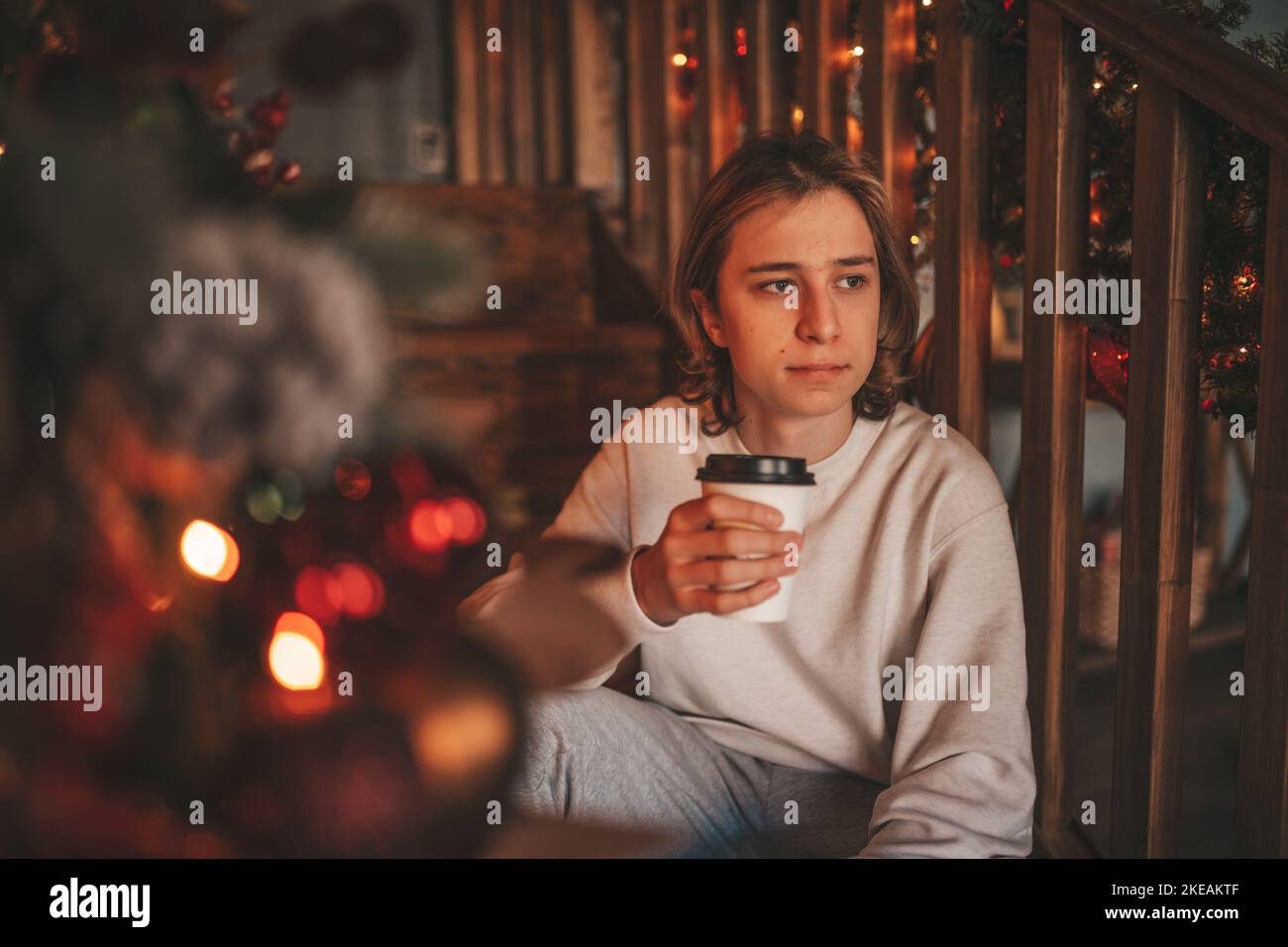 Young teen boy with long hair thoughtful look sad eyes negative mood ...