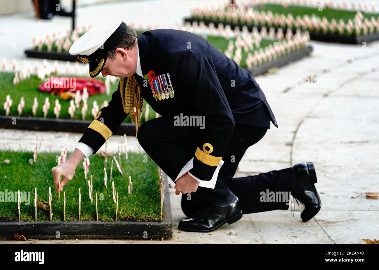 A Royal Navy Commodore plants a cross of remembrance during an ...