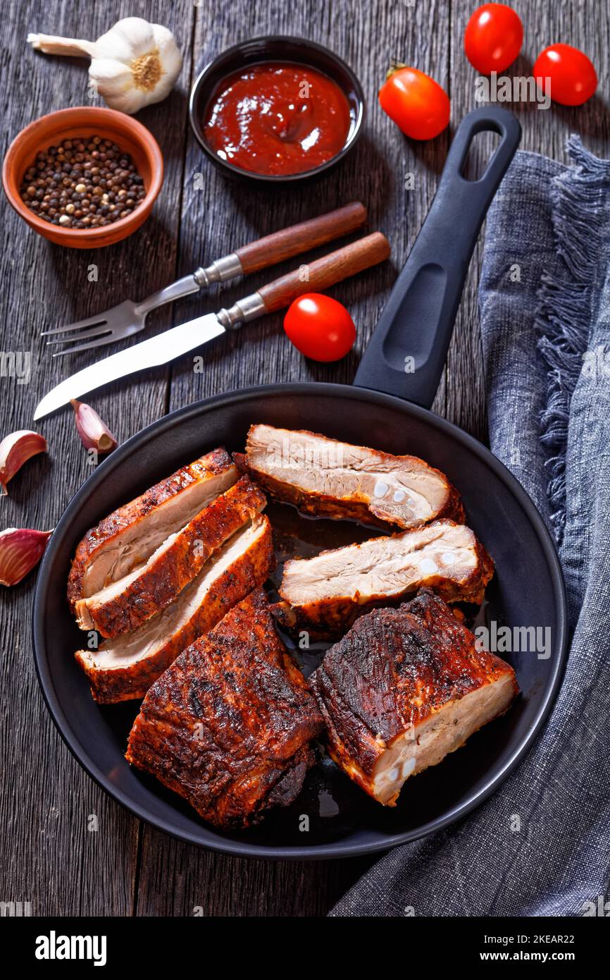 roast baby back pork meaty ribs in a pan on dark wooden table with ...